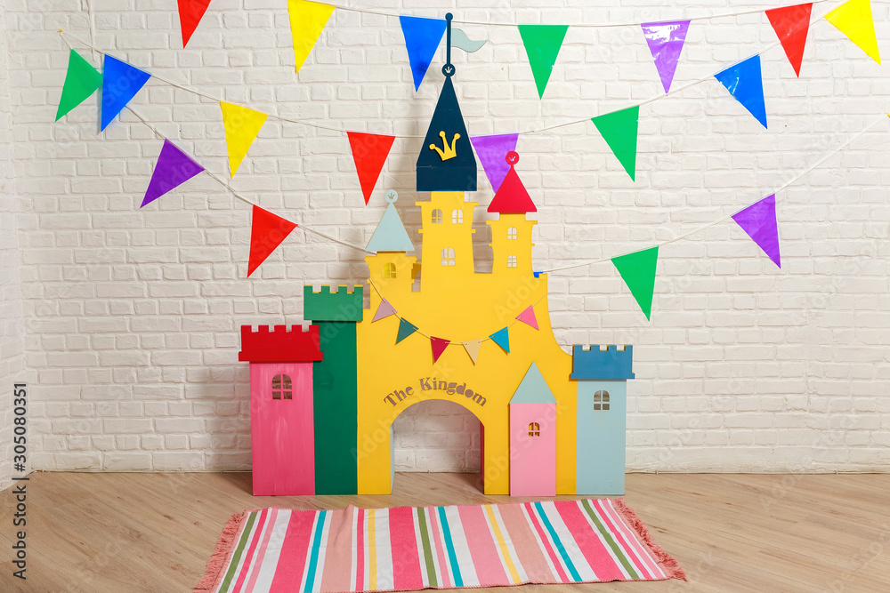Children's colorful plywood castle on a background of flags and a white ...