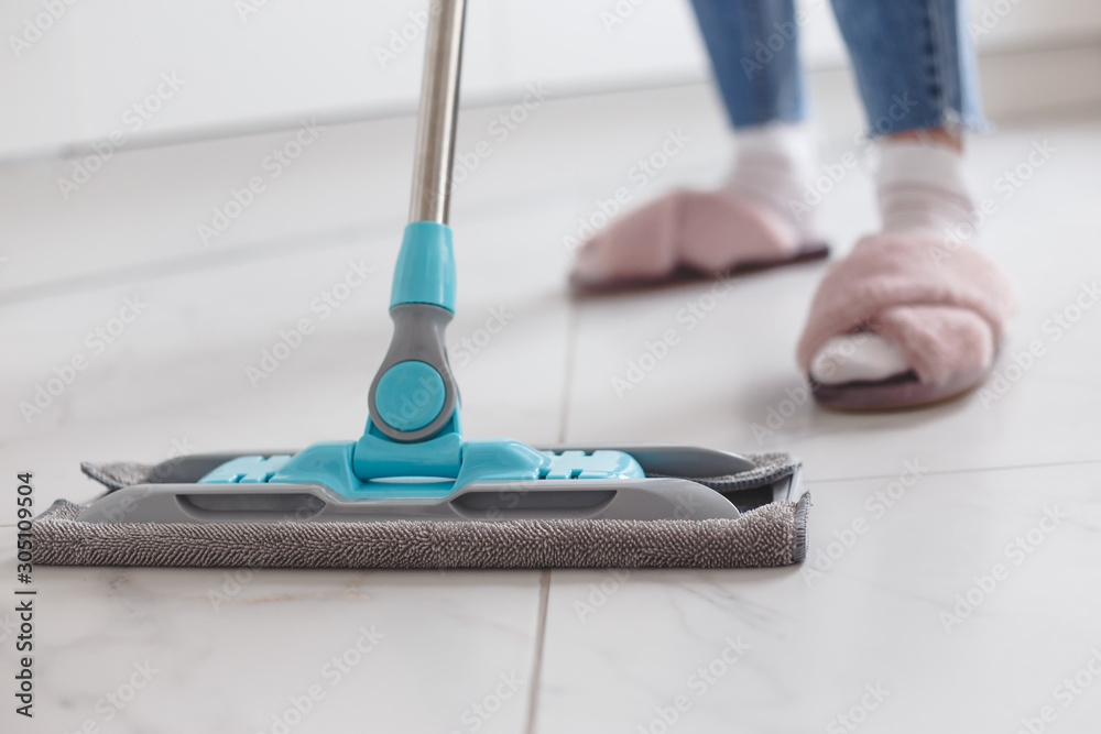 Housewife mopping floor made of porcelain tiles in the kitchen. Stock ...