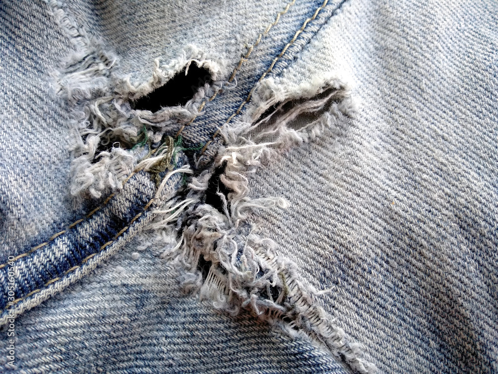 Ripped destroyed jeans background. Jeans torn denim texture. Blue jeans ...