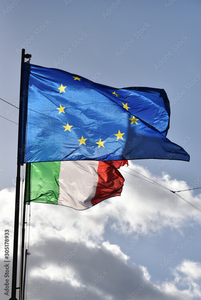 European flag and italian flag waving together in a clear blue sky ...