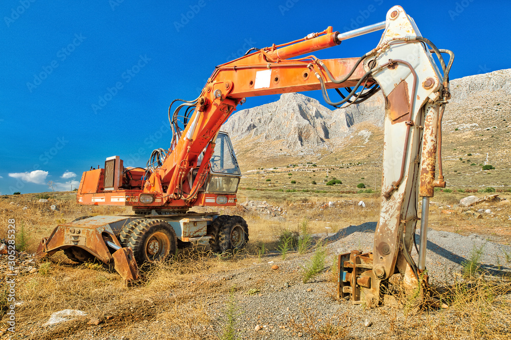 Side view of long arm of excavator in a mine with sand, earth and ...