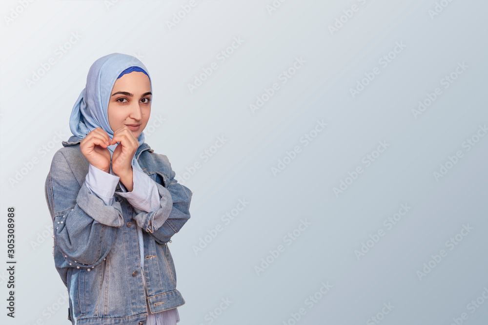 Young Arabian Muslim woman in hijab showing shape heart with hands ...
