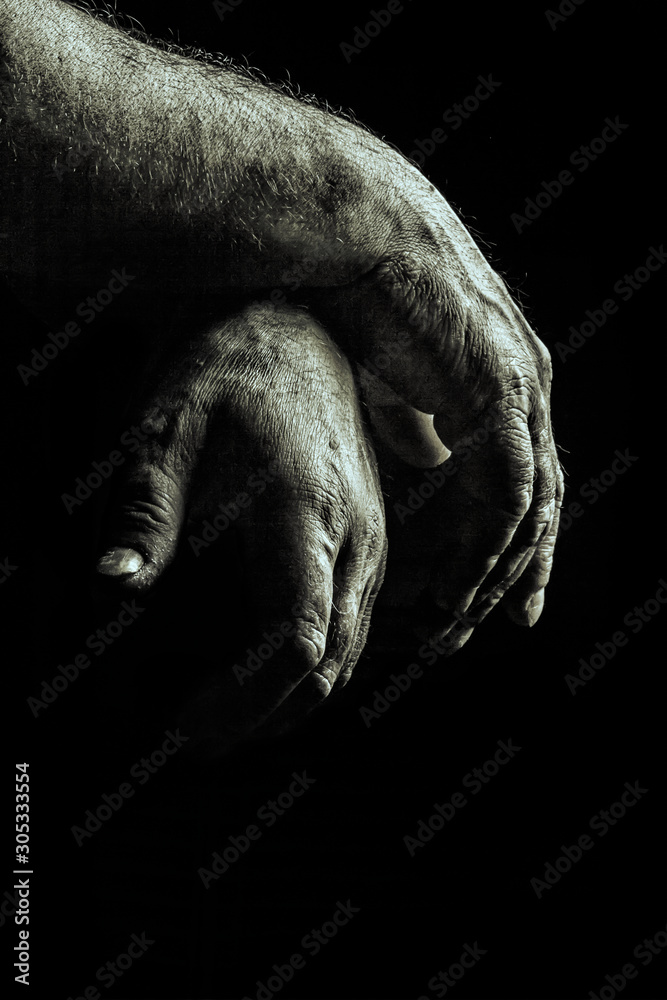verry old male praying hands with ring in front of black background ...
