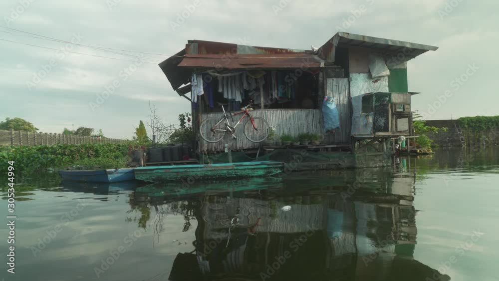 A squatters home reflects on the waters of the flooded Artex compound ...
