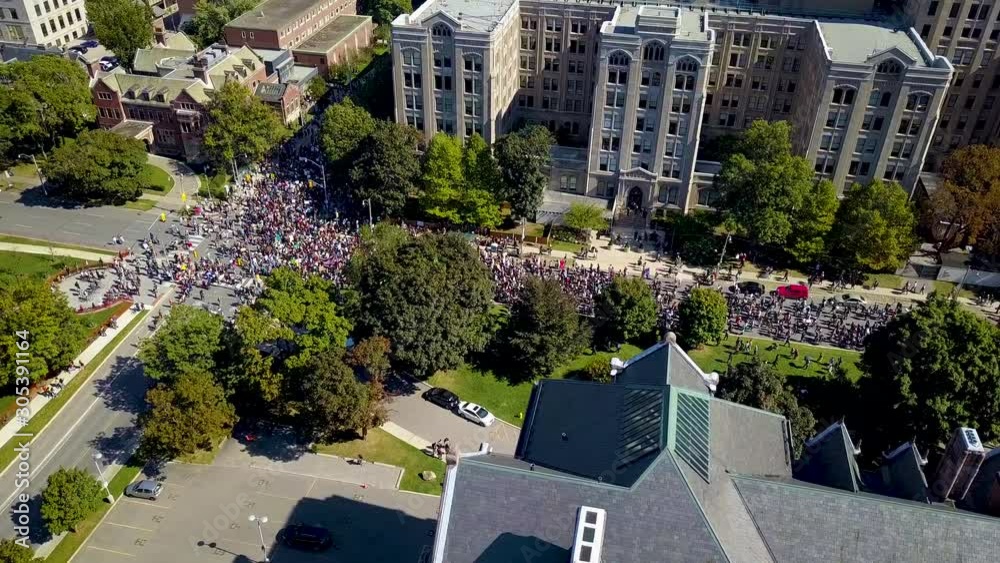 Huge crowd marches past old buildings in Toronto, aerial drone pan ...