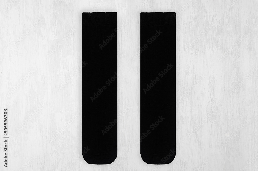 Pair blank black tall socks front view flat lay on white wood board as ...