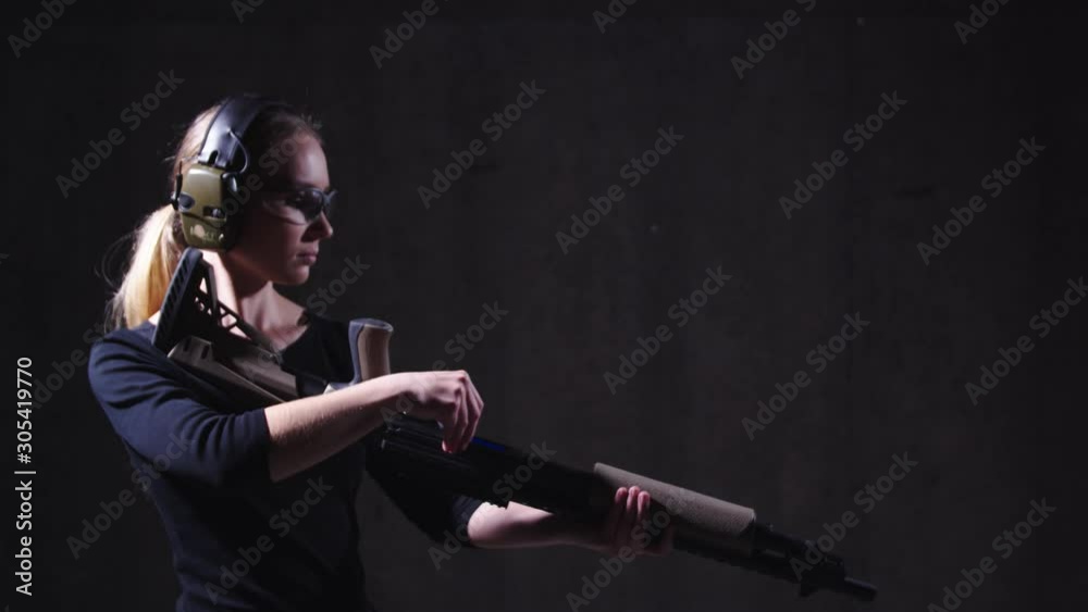 Woman loading shotgun with ammo, person reloading her weapon in ...