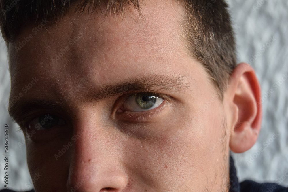 close-up of the eye and part of the face of a young man with clear eyes ...
