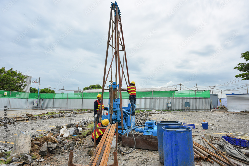 Construction workers drilling obtaining soil samples field for ...