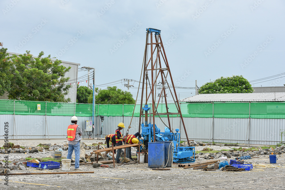 Construction workers drilling obtaining soil samples field for ...