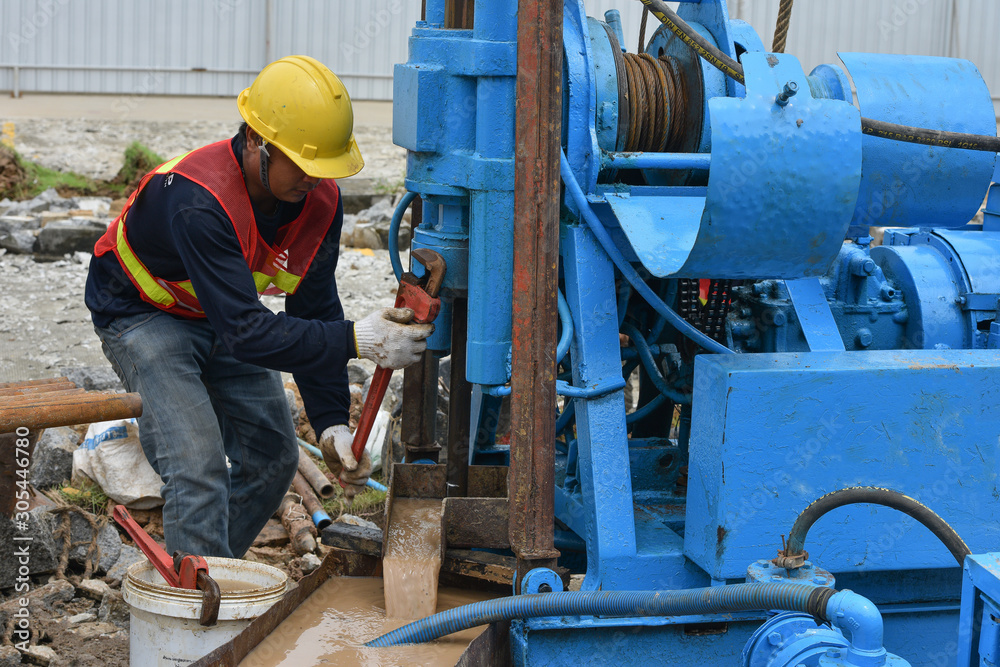Construction workers drilling obtaining soil samples field for ...