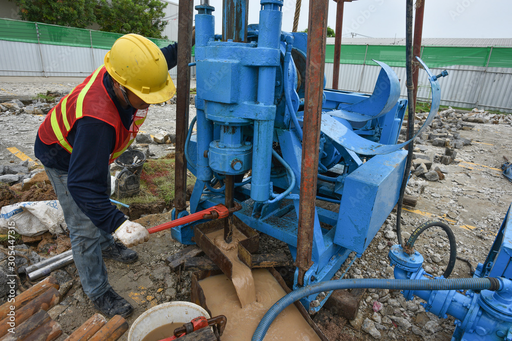 Construction workers drilling obtaining soil samples field for ...
