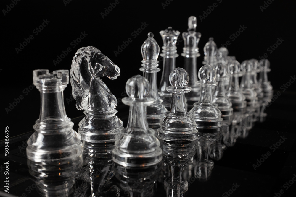 Transparent methacrylate chess pieces, side view placed on a black ...