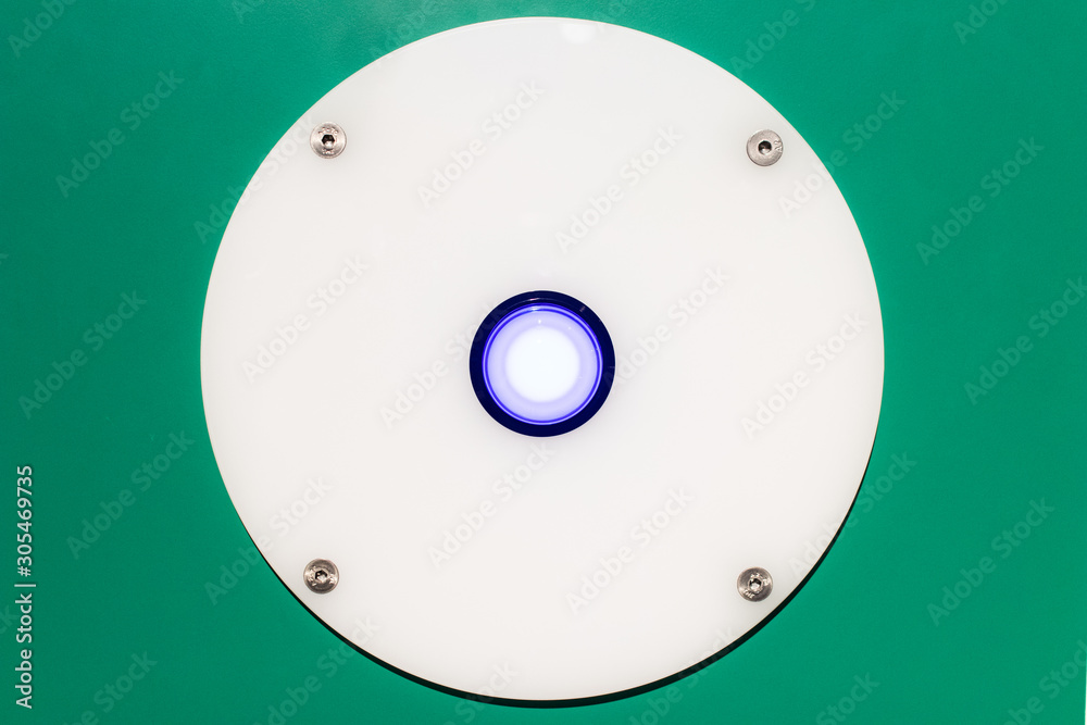 illuminated blue button on a white frame on a green background. button ...