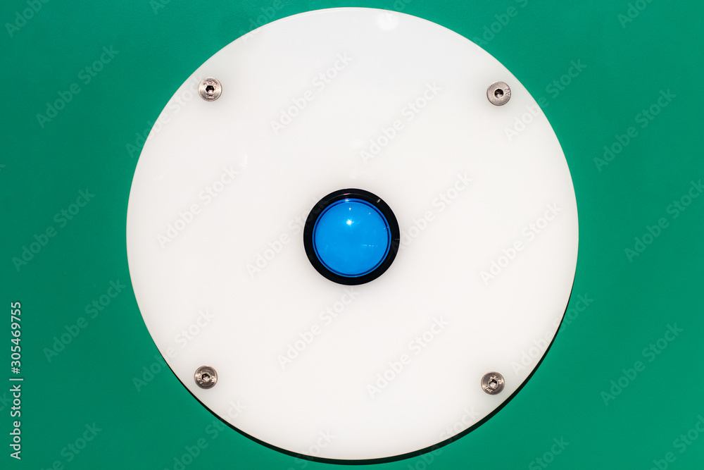 illuminated blue button on a white frame on a green background. button ...