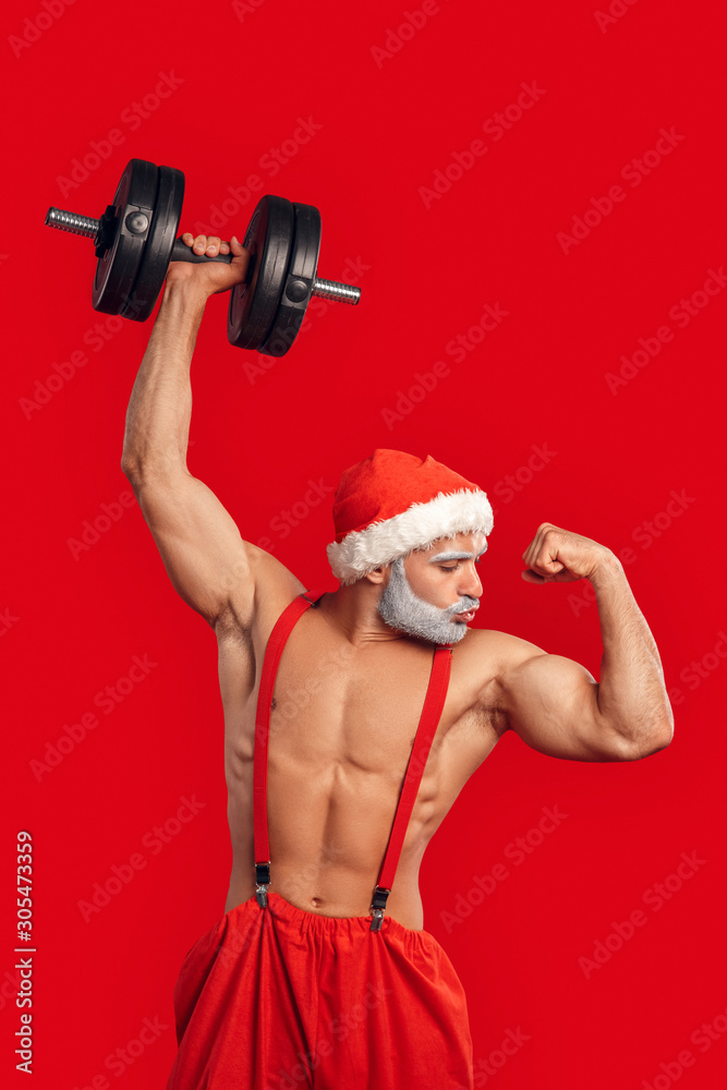Christmas Freestyle. Young Santa Claus bare muscular upper body in hat ...