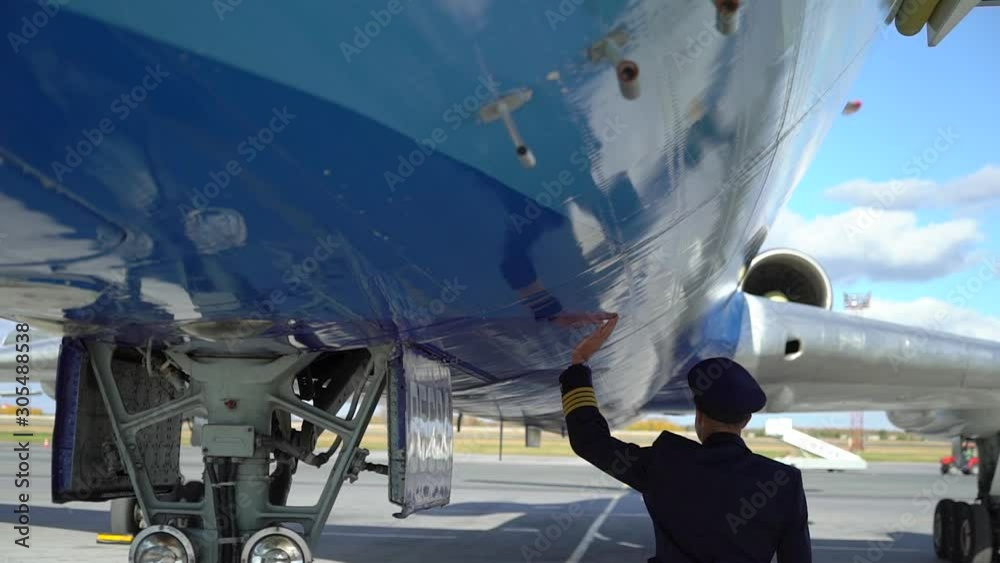 Professional male pilot capitan in uniform on background modern air ...