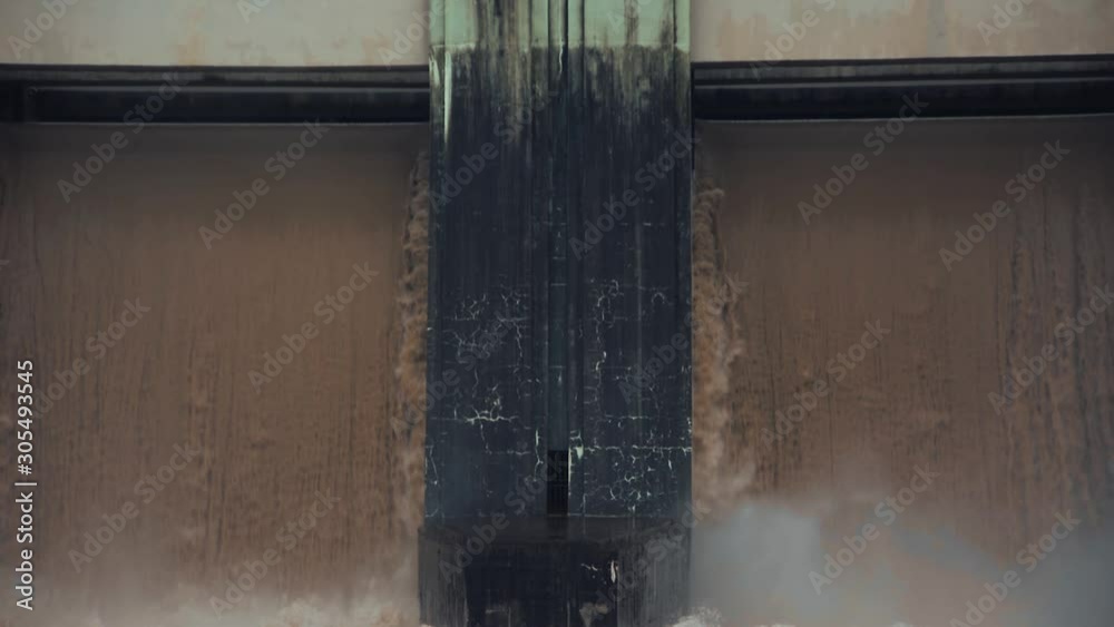 Low angle water flows in concrete channel under small bridge at hydro ...