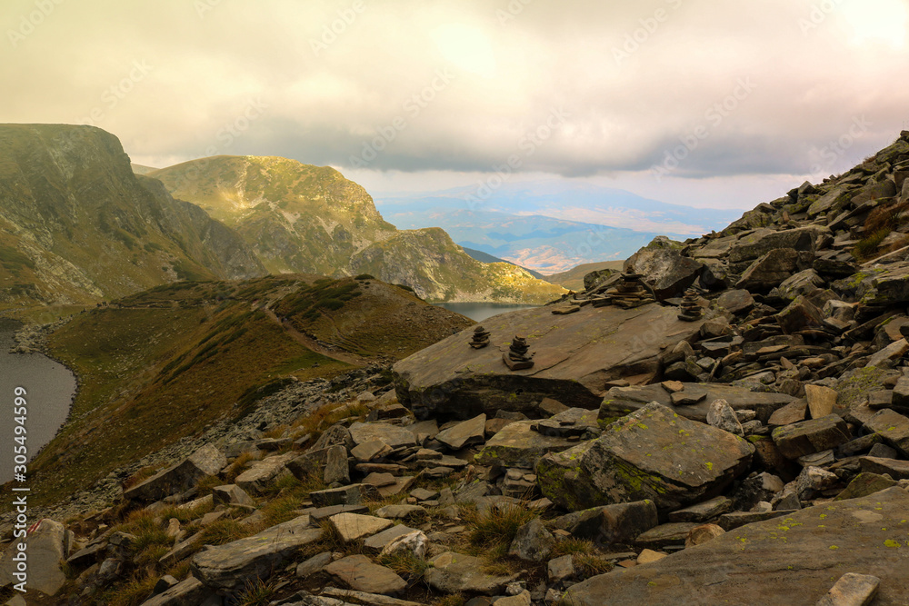 Balanced stone pyramide. Mountains landscape. Grey sky. Stone pyramids ...