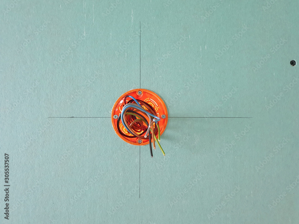 Electrical outlet mounting box. Wall made of plasterboard. Multicolored ...