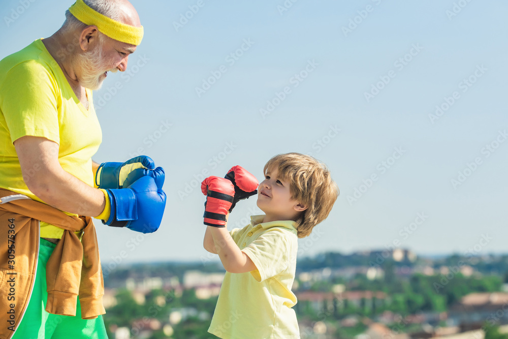 Grandpa and little child boy in boxing stance doing exercises with ...