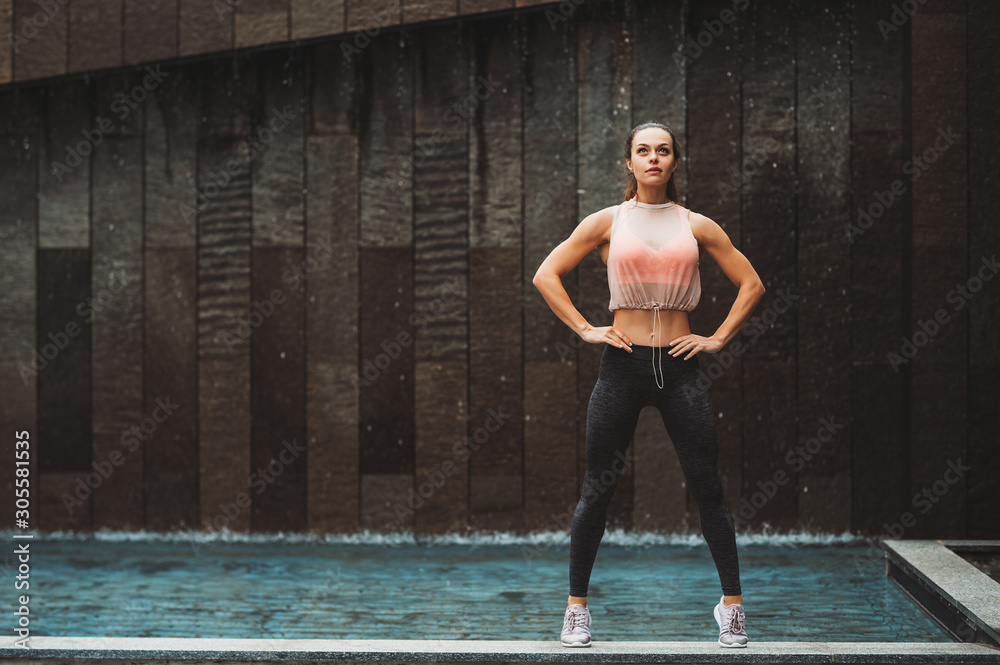 Outdoor portrait of young beautiful fit woman, wearing fashionable ...