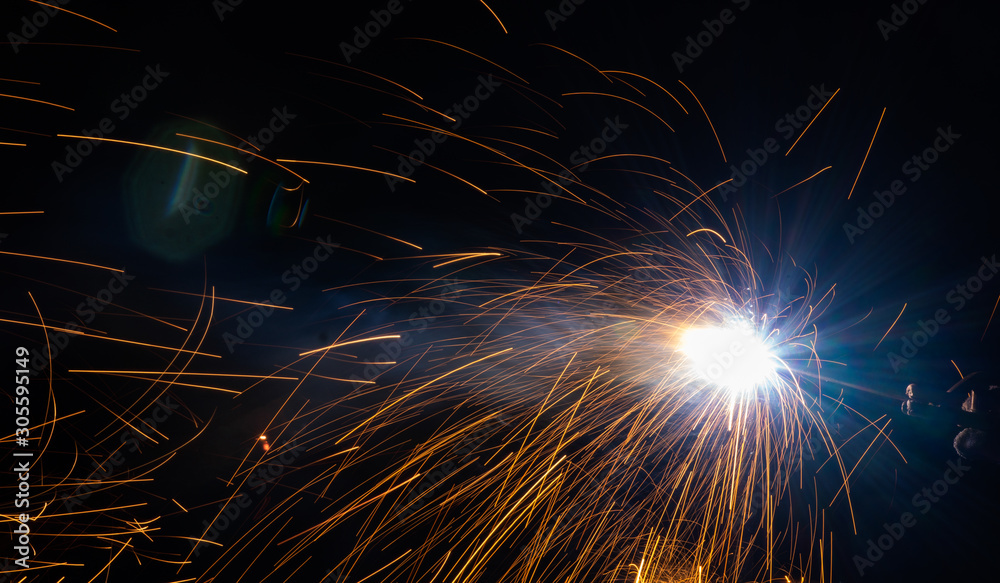 Glowing flow of steel metal welding spark dust particles shine in the ...