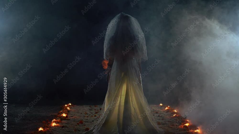 A ghost bride surrounded by candles standing in a dark scary room ...