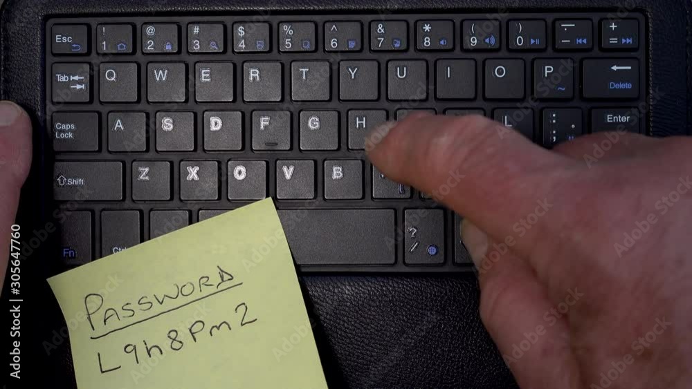 Close overhead shot of a man’s hands typing the password on a ...
