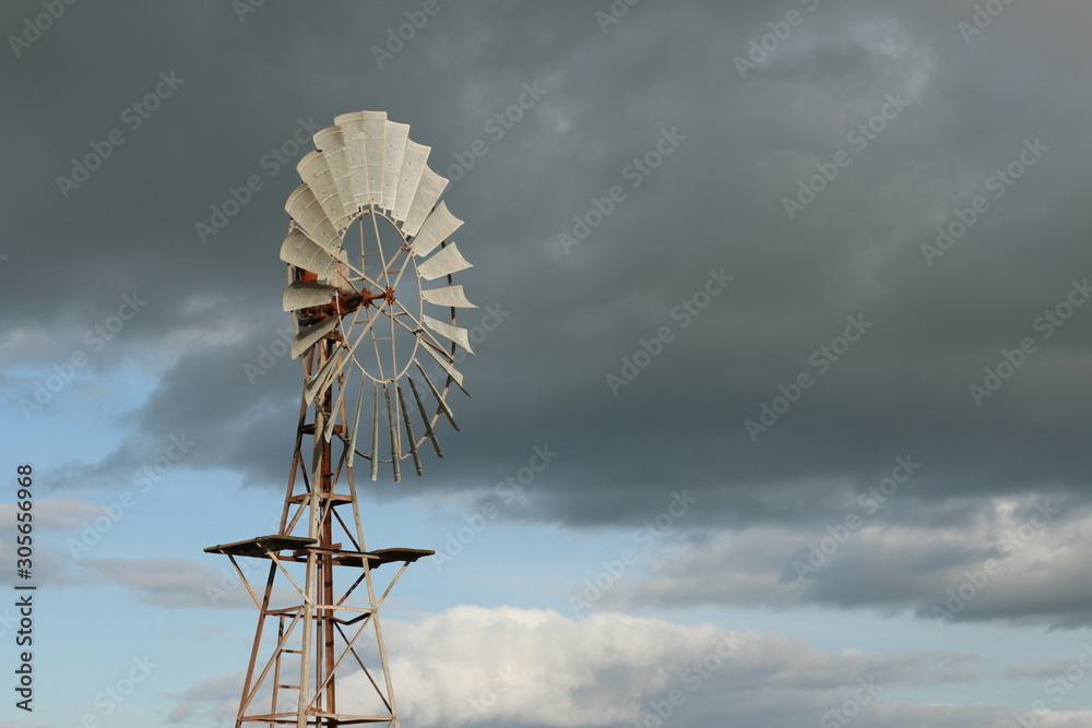 water wind mill next to a large water storage tank on an agricultural ...