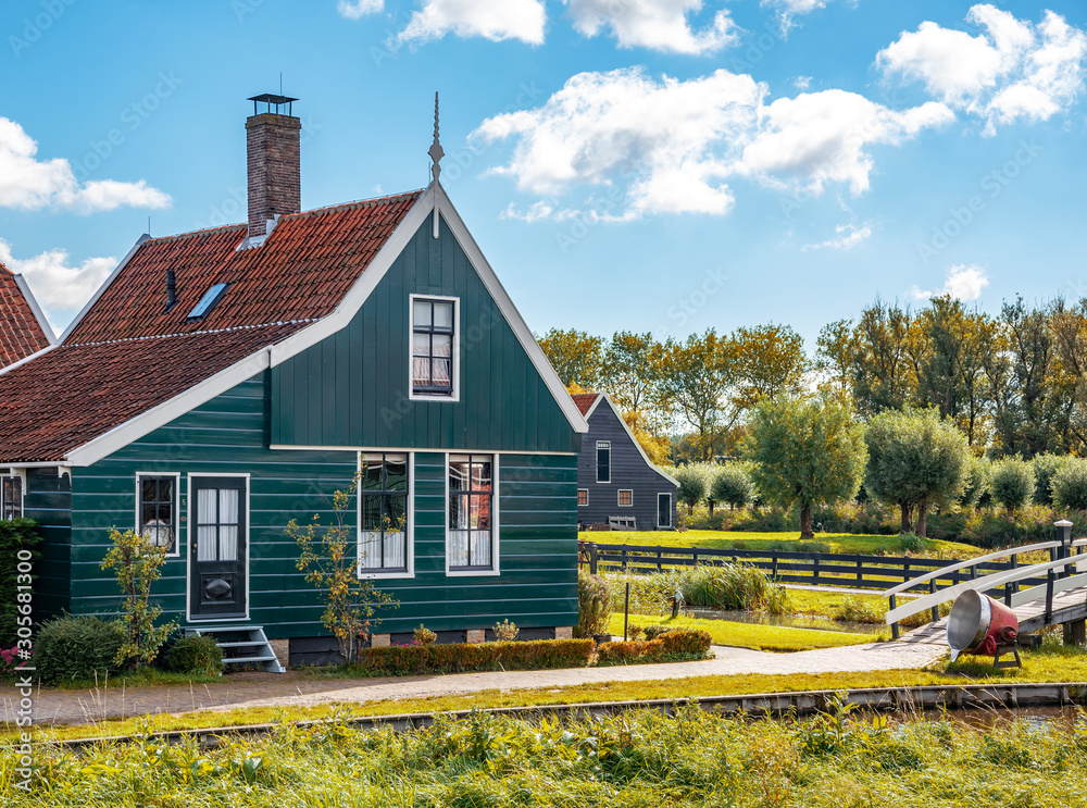 Country wooden house surrounded by green trees. Volendam village in the ...