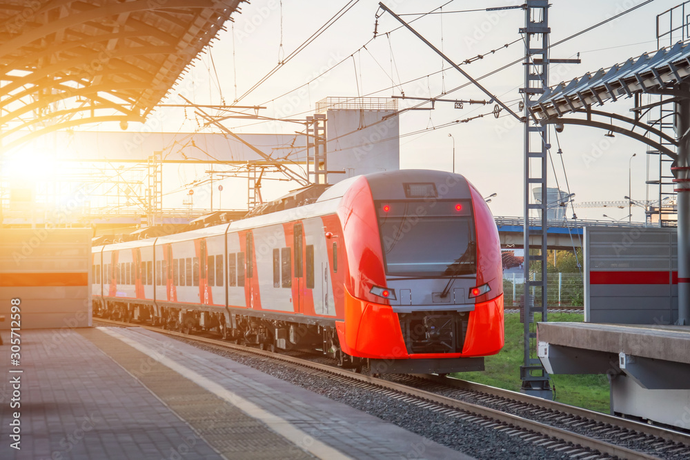 Passenger electric train departs from the station platform and rides on ...