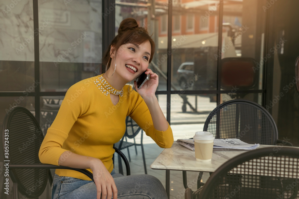 Charming woman calling with cell telephone while sitting alone in ...