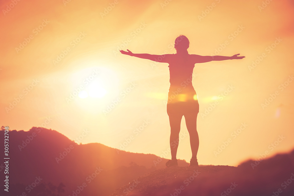 Copy space of woman rise hand up on top of mountain and sunset sky ...