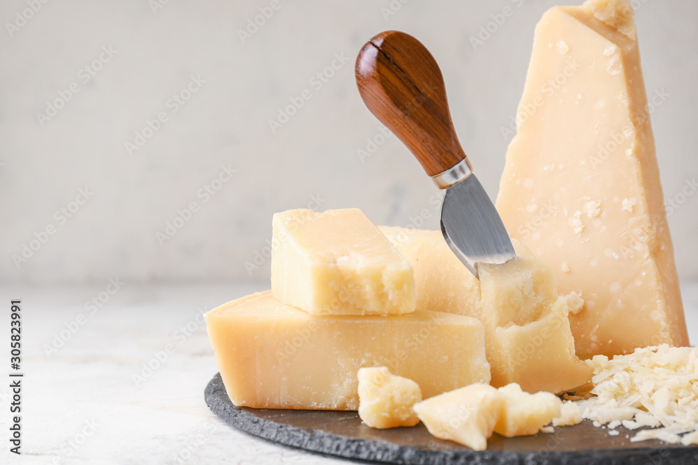 Slate plate with tasty Parmesan cheese on light background Stock Photo ...