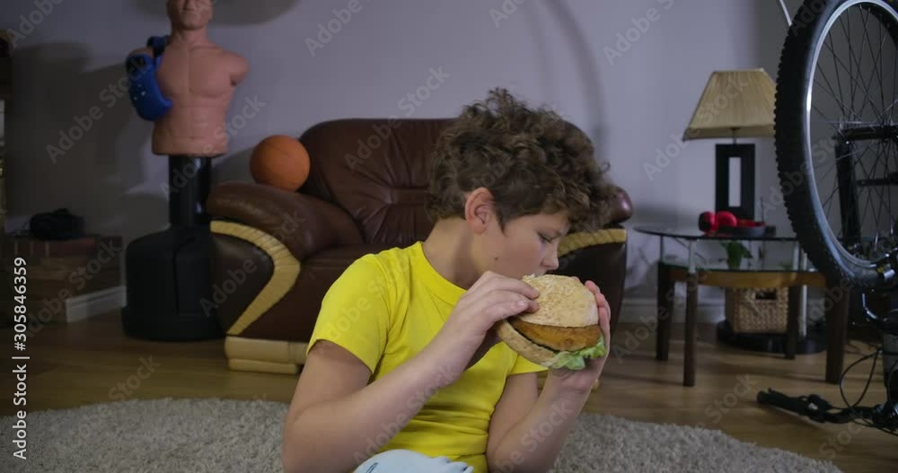 Vídeo do Stock: Absorbed Caucasian teenage boy watching TV, chewing ...