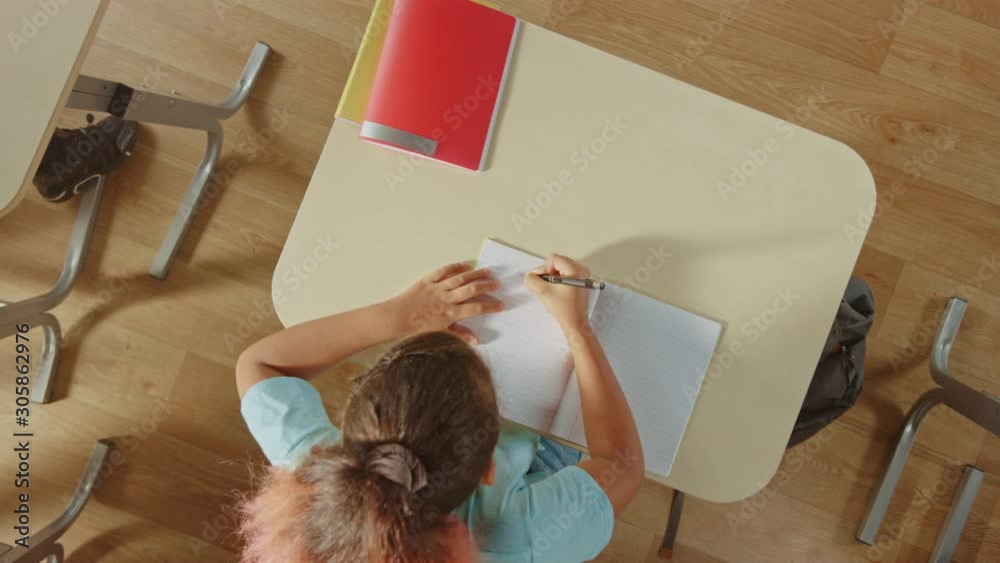 Elementary School Classroom: Girl Sitting at the School Desk Working on ...