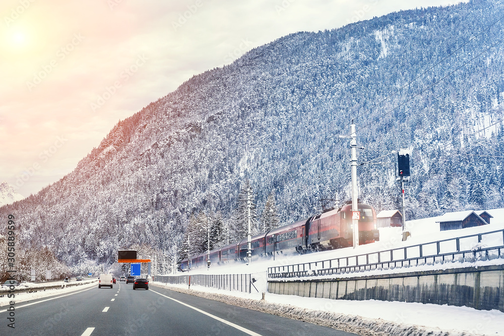 Winter alpine mountain highway and parallel railway road with intercity ...