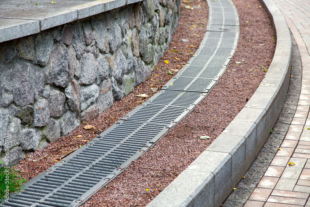 grille of the drainage system on the curve pedestrian sidewalk of turn ...