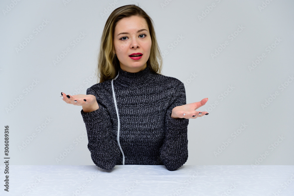 Concept of a talking woman sitting at a table in front of the camera ...
