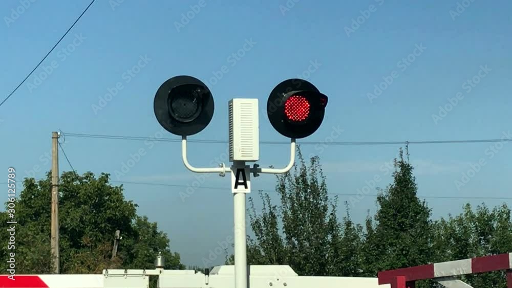 Close-up of red flashing traffic lights at a railway crossing with a ...