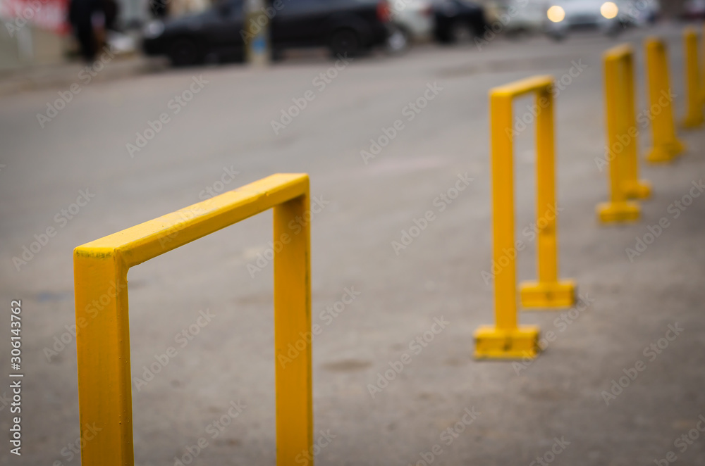 Yellow iron barriers blocking parking. Close-up of fences protecting ...