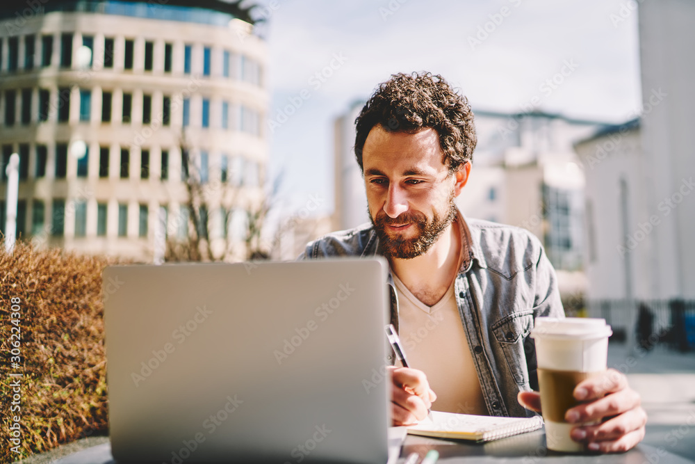 Skilled creative caucasian male blogger working remotely outdoors on ...