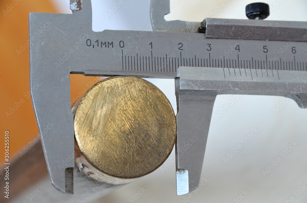 Sliding caliper measures the diameter of the brass rod. An old vernier ...