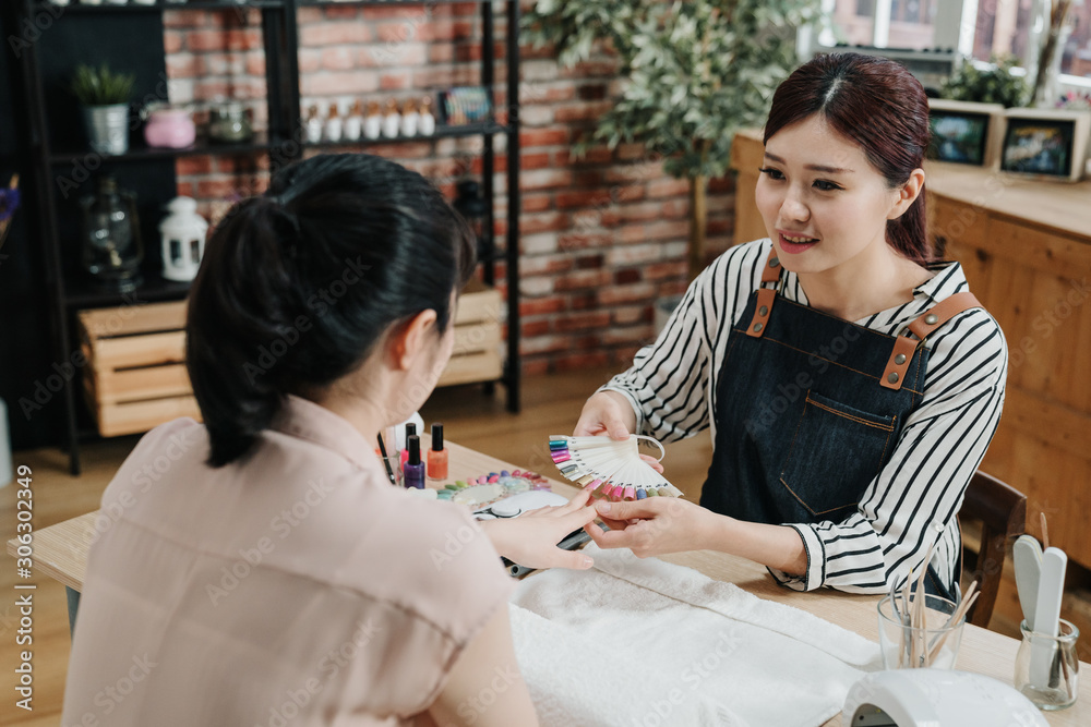 Summer manicure and nail color samples. Master woman manicurist helping ...