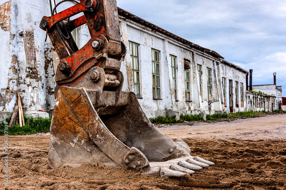 Big red rusty bucket of excavator digger at bulding site with long ...