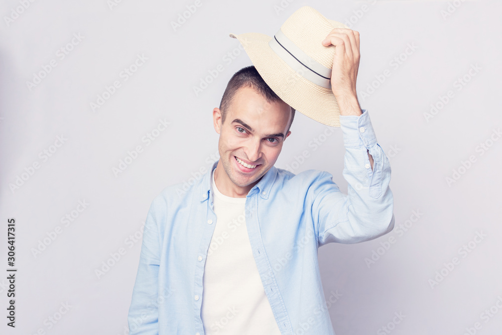 Attractive man in hat smiles and takes off his hat, man welcomes you ...