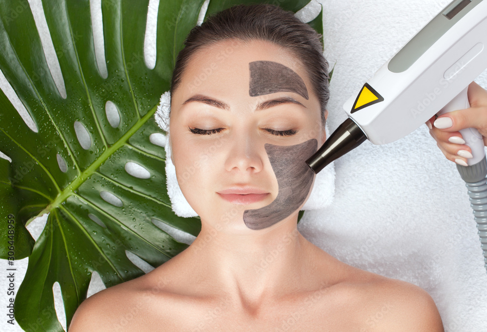 Cosmetologist does Carbon face peeling procedure of a beautiful, young ...