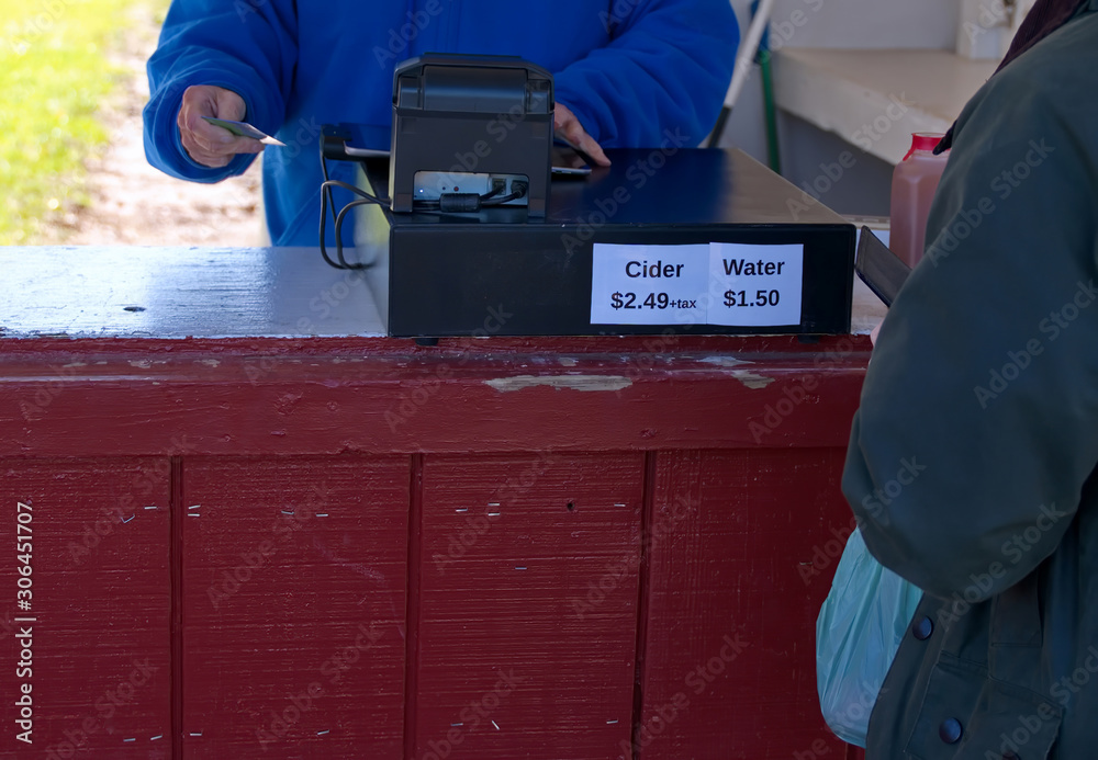 Water and cider price signs on a cash register at an orchard outdoor ...