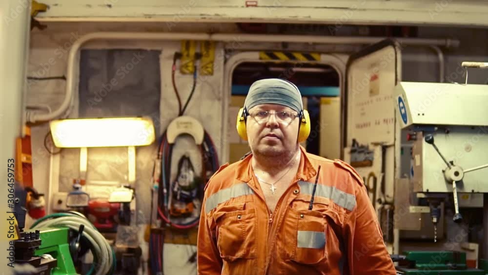 Marine engineer inspecting ship's engine in engine control room ECR ...